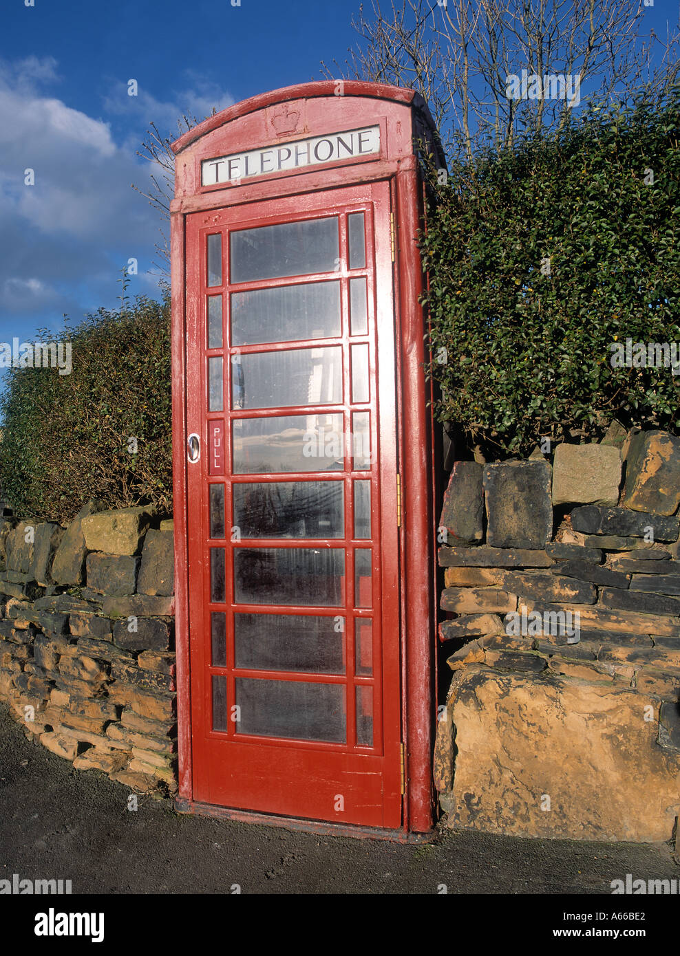 RED TELEPHONE BOX WITH STONE WALL AND BLUE SKY Stock Photo - Alamy