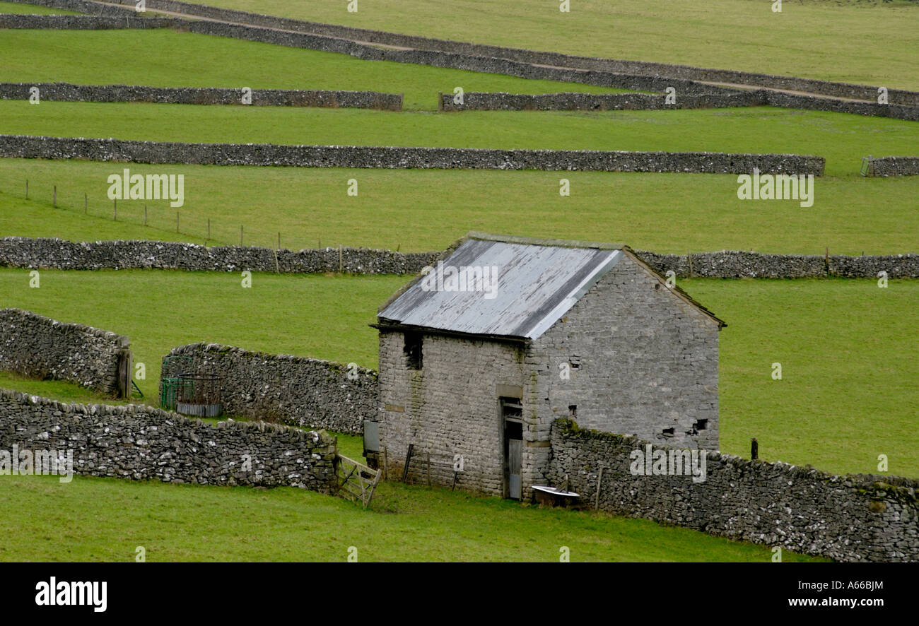 A brick built barn stands among the small fields separated by dry stone ...