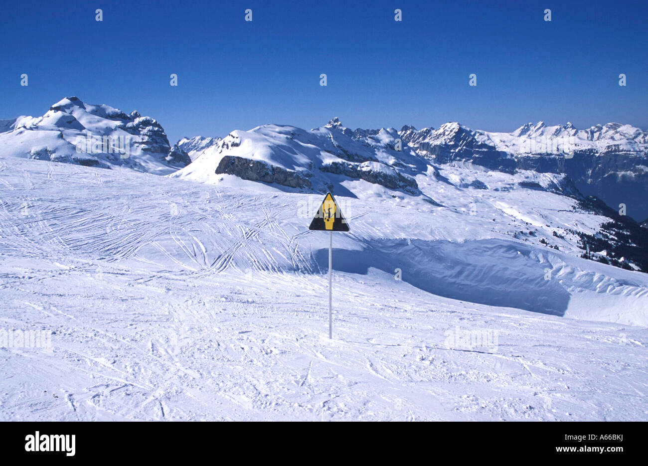 Warning sign on a piste showing a person falling down a crevasse Flaine ...