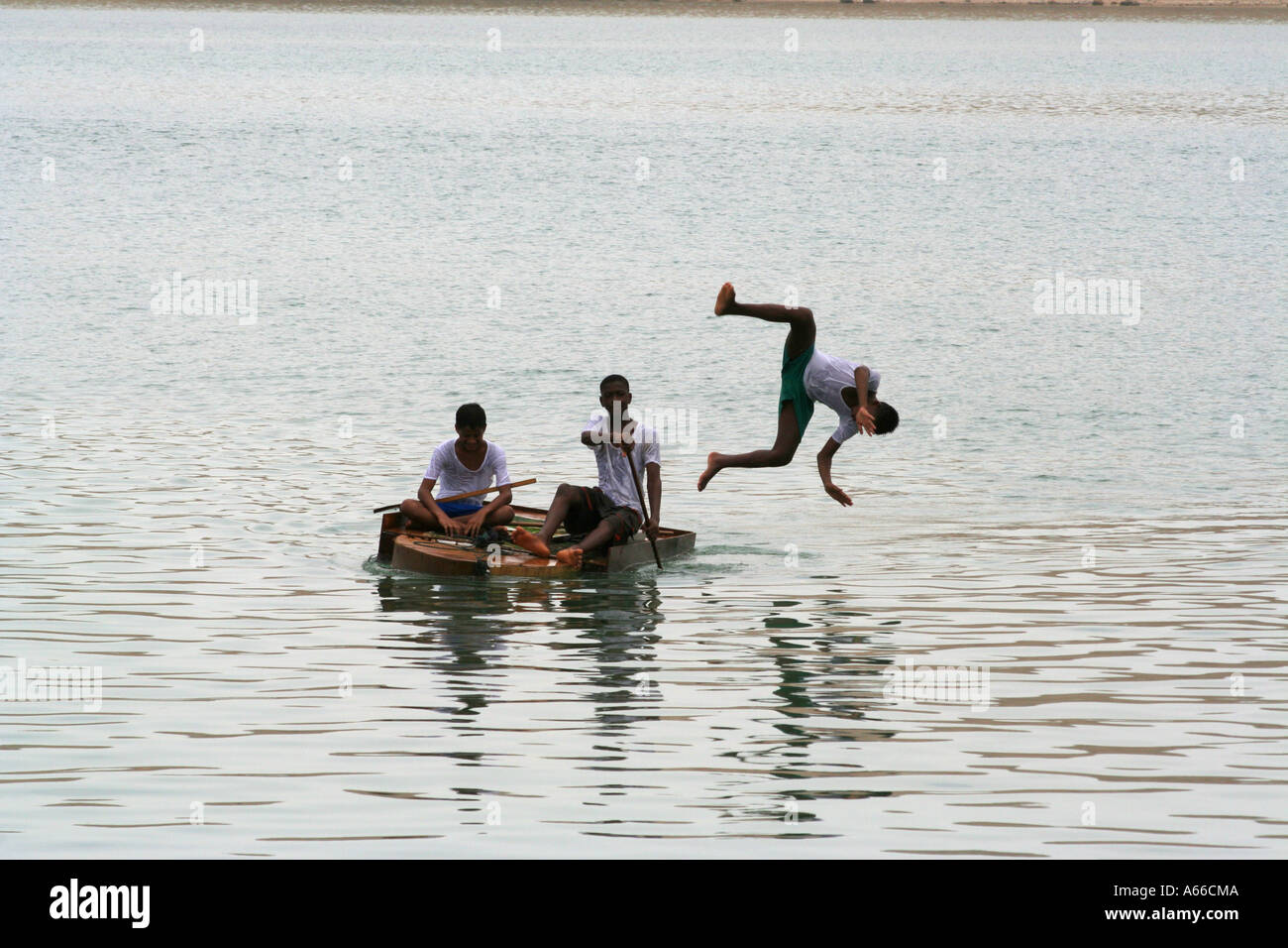 Boy dives off of a makeshift boat, Sur, Oman Stock Photo - Alamy
