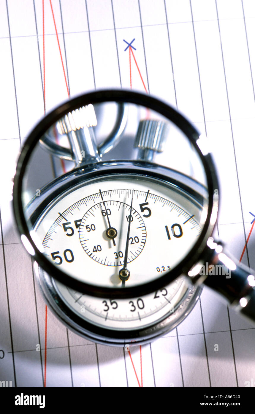 Stopwatch through a magnifying glass Stock Photo - Alamy