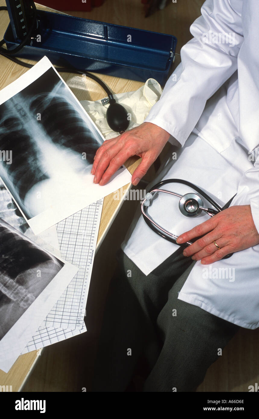 Doctor in surgery holding a stethoscope with chest x-ray on the desk ...