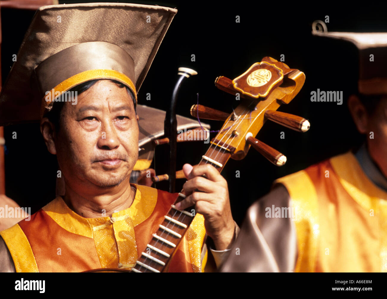 Musician in traditional dress playing the Ruan in the Confucian temple ...