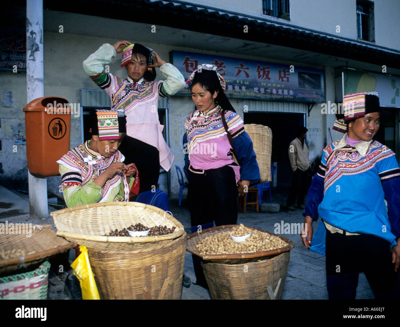Women of Yi ethnic minority in traditional dress selling peanuts in the ...