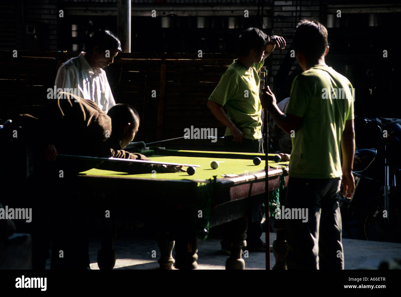 Young men playing billiards outside in the early sun. China Stock Photo ...