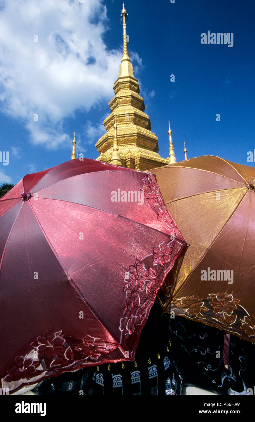 Two colourful silk umbrellas in front of a golden pagoda in Mengla ...