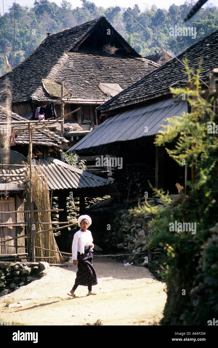 Woman of Bulang minority walks between the traditionally built houses ...