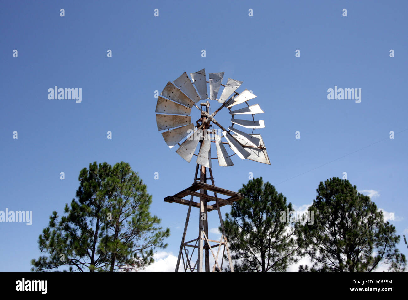 A SILVER WINDMILL AGAINST A BLUE SKY BAPDb10319 HORIZONTAL Stock Photo ...