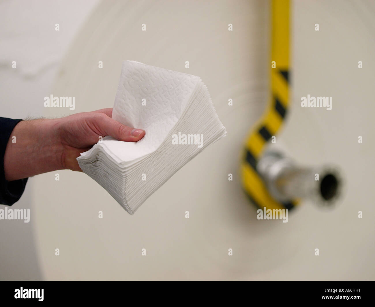 Hand man holding tissues made from the large roll of raw paper in the ...