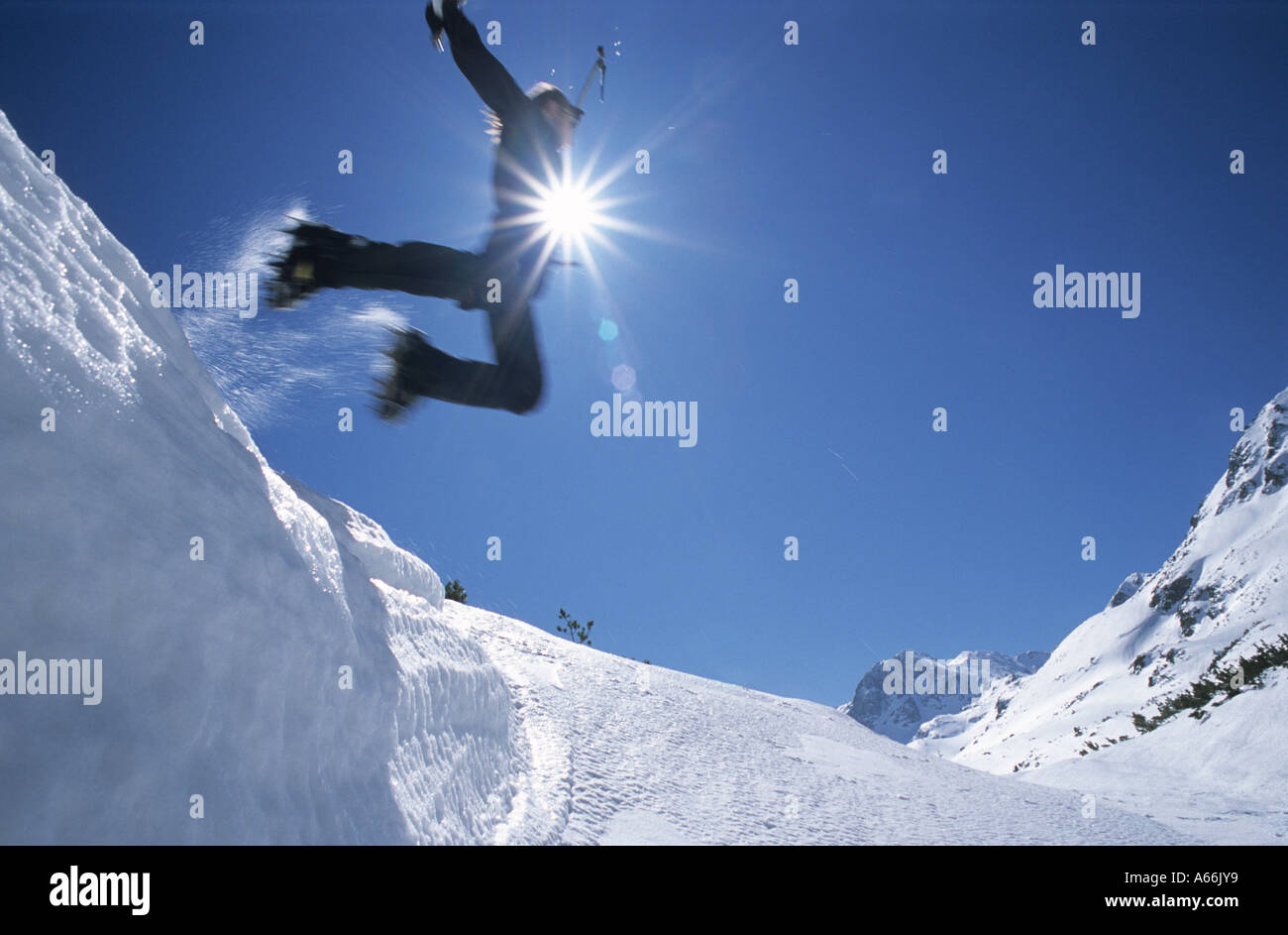 Winter climber jumping over a cliff Stock Photo - Alamy