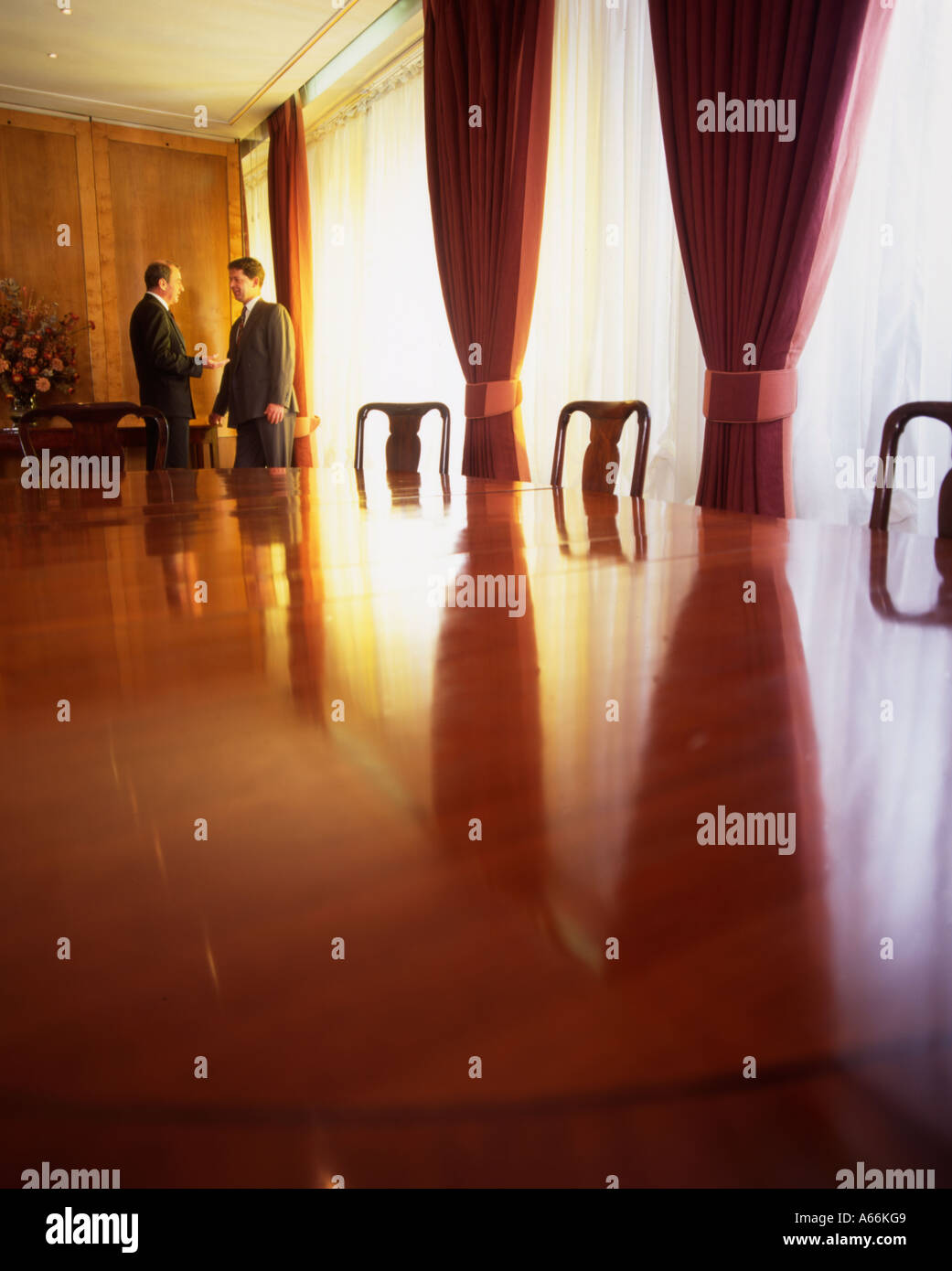 Businessmen talking informally with boardroom table in classic London ...