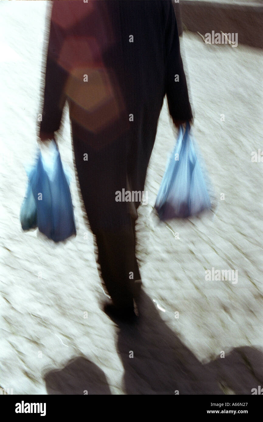 man walking with two shopping bags blur Stock Photo - Alamy