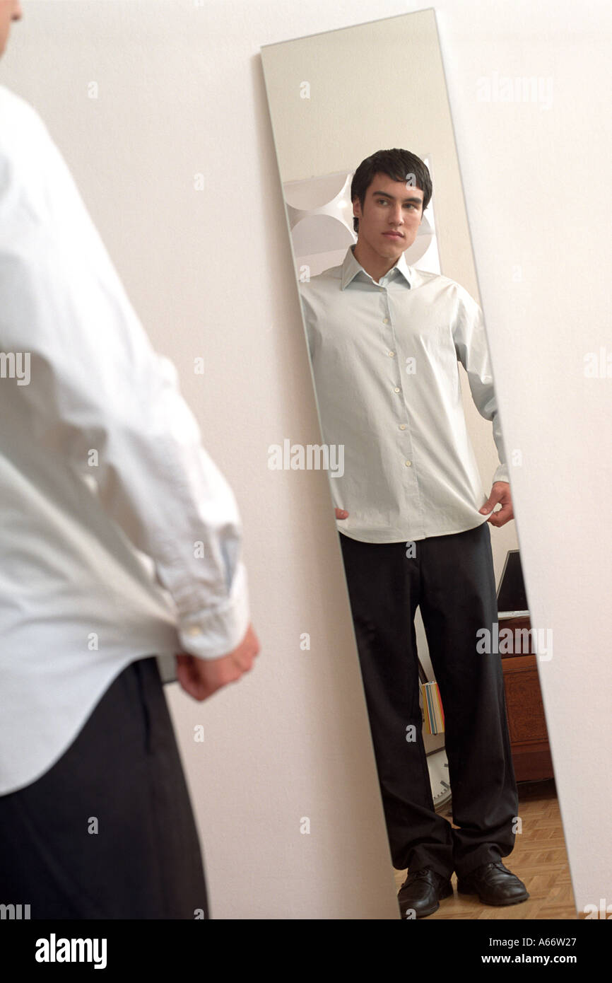teenage boy checking his appearance in the mirror Stock Photo - Alamy