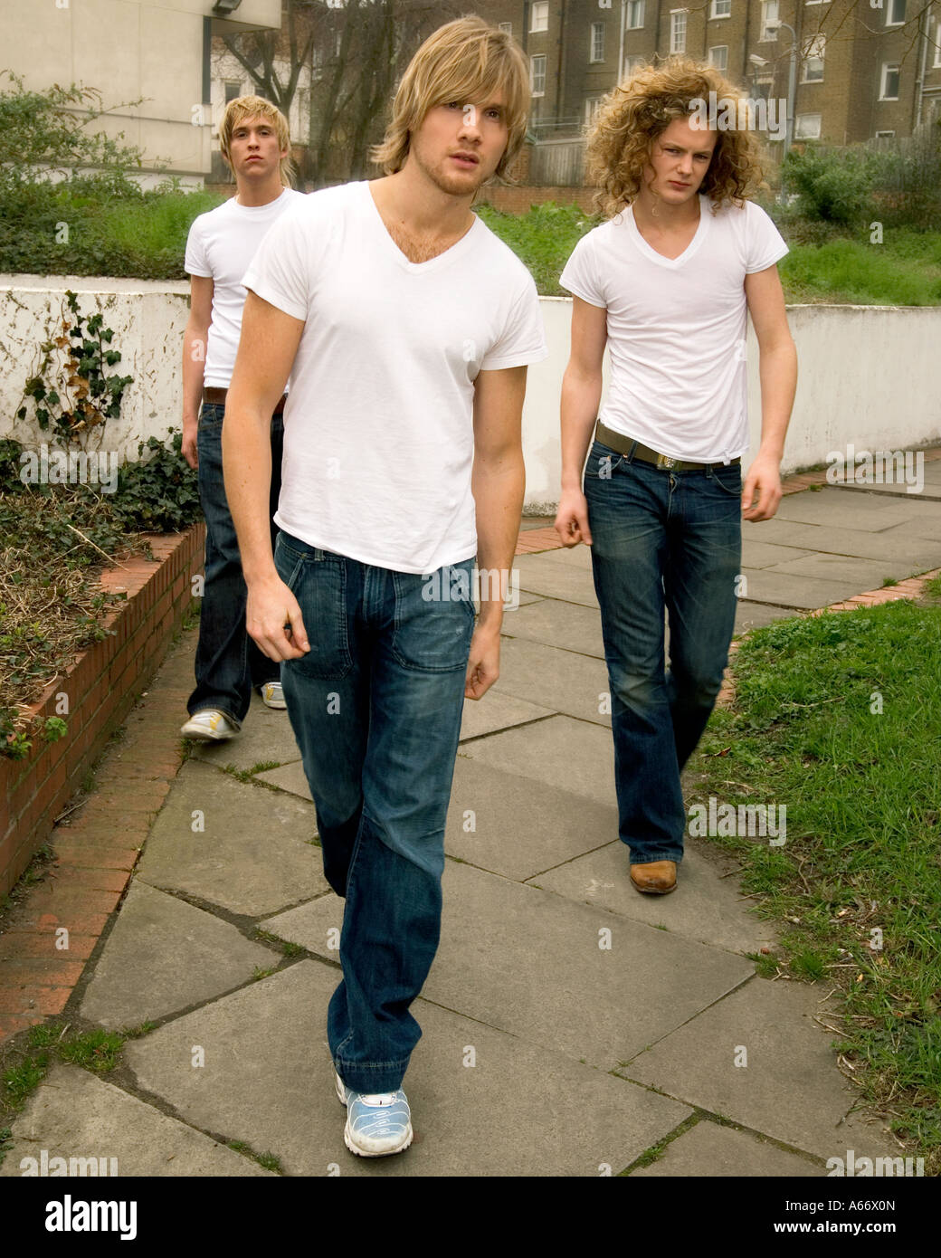 Three young men walking down a pathway Stock Photo - Alamy