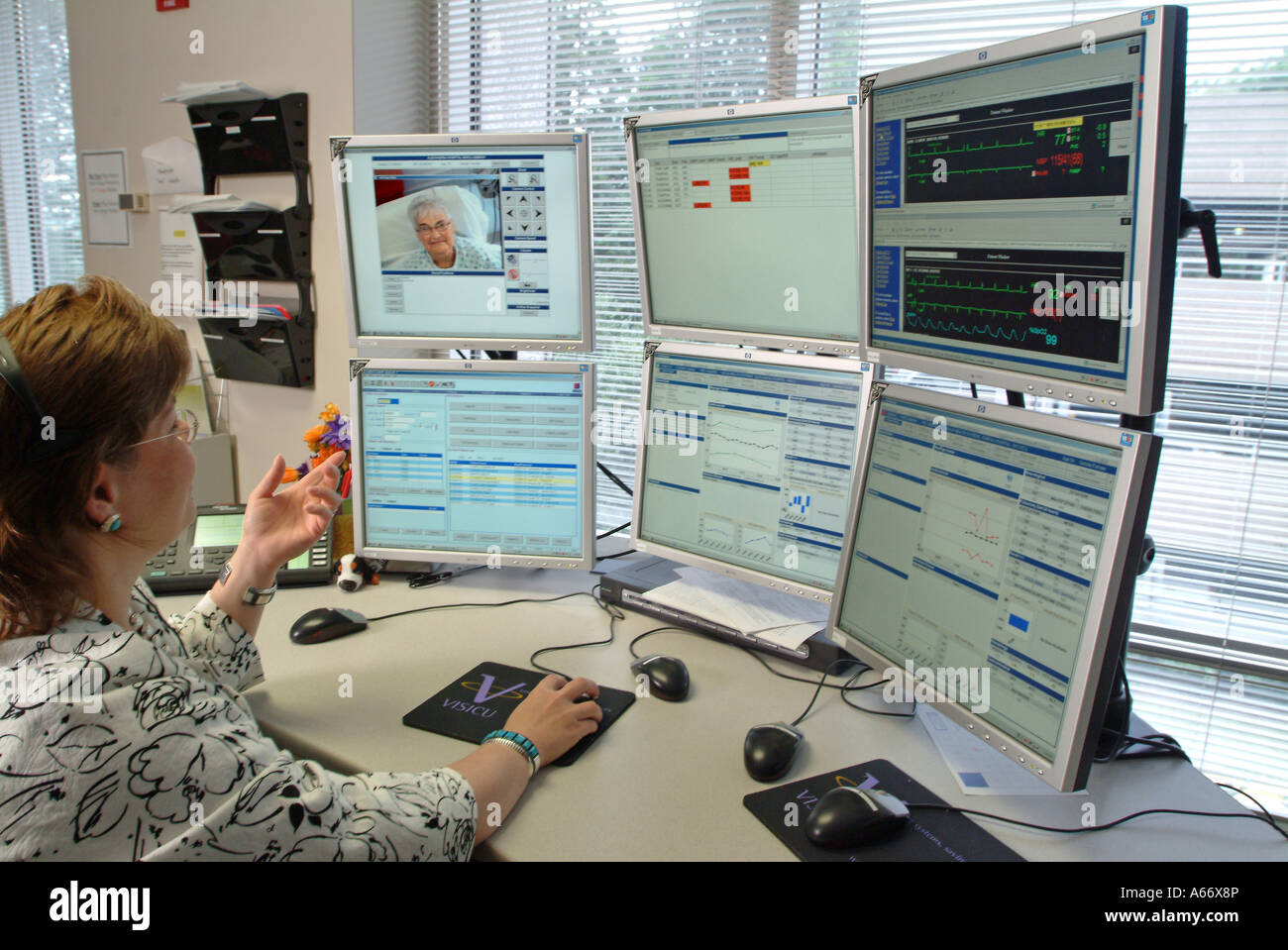 A nurse checks on patients from a remote location via computer and ...