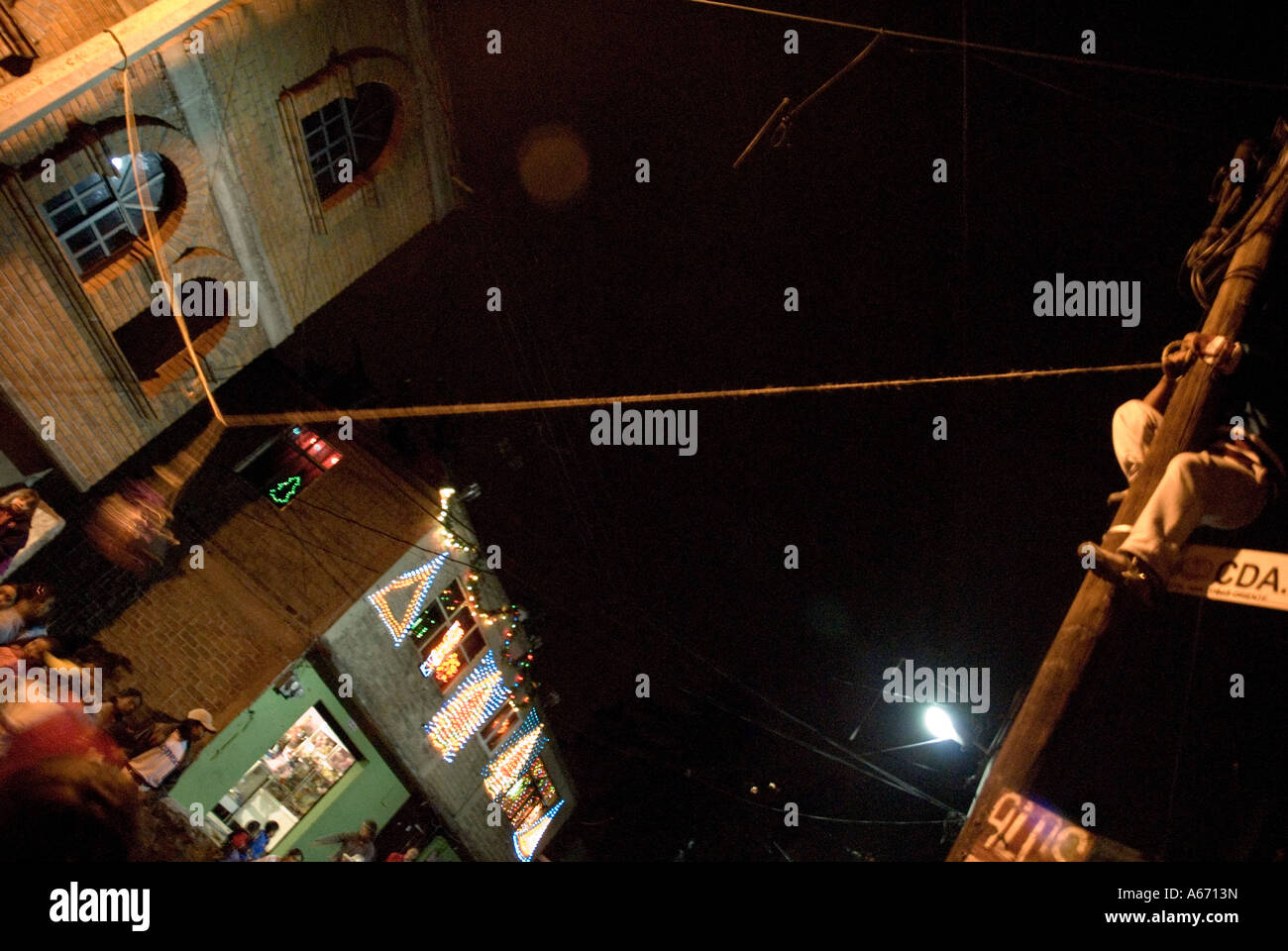 man climb a pole and hold a rope - breaking the pinata - posada, the ...
