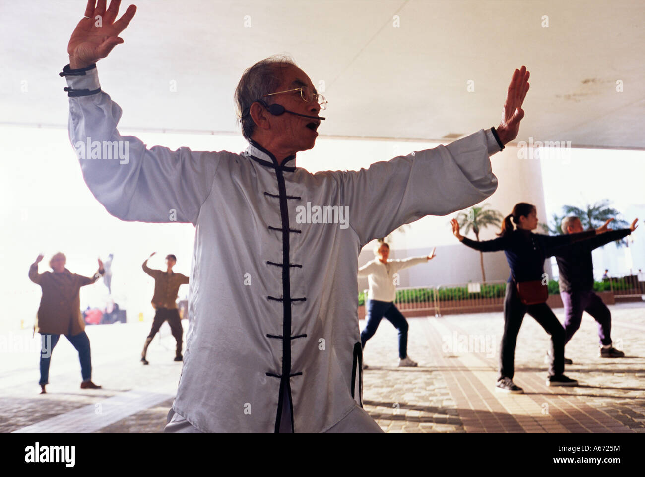 An instructor leads a group in Tai chi near the Kowloon waterfront at ...
