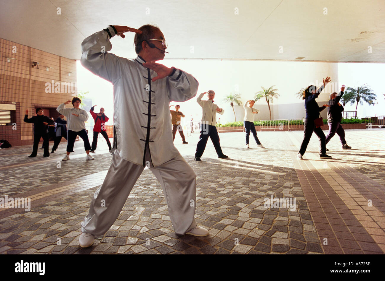 A group perform Tai chi near the Kowloon waterfront at Tsim Sha Tsui ...