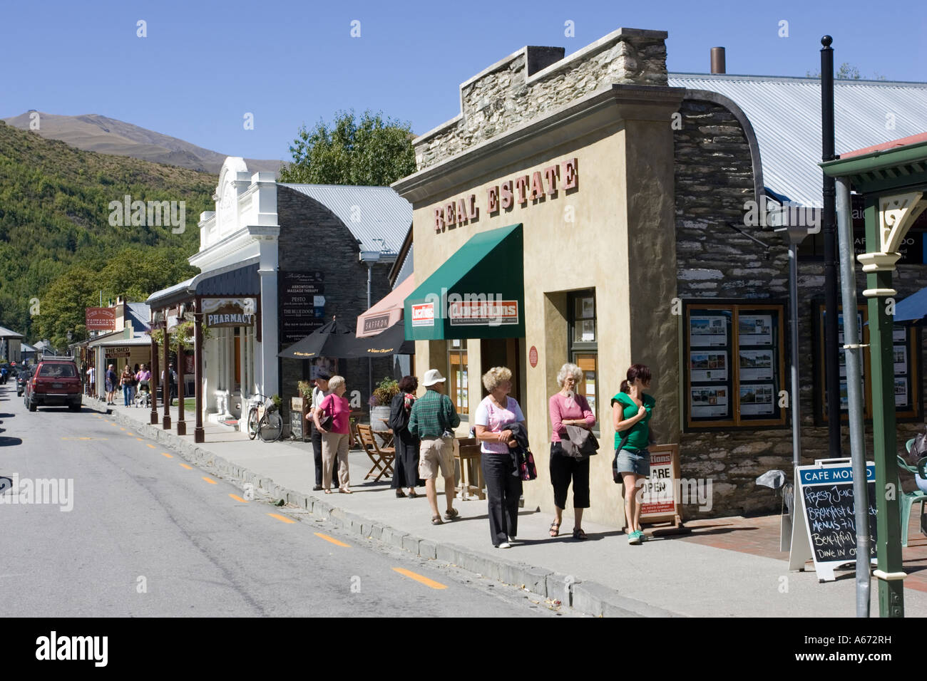 Shoppers looking in old timber buildings now shops in main street in ...
