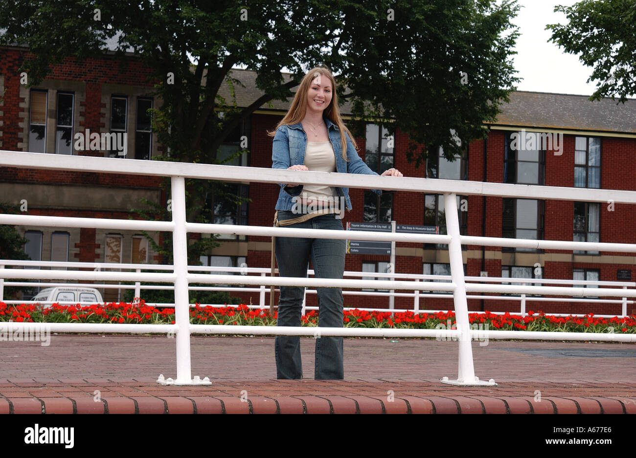 teenage girl standing next to railings outside Stock Photo - Alamy