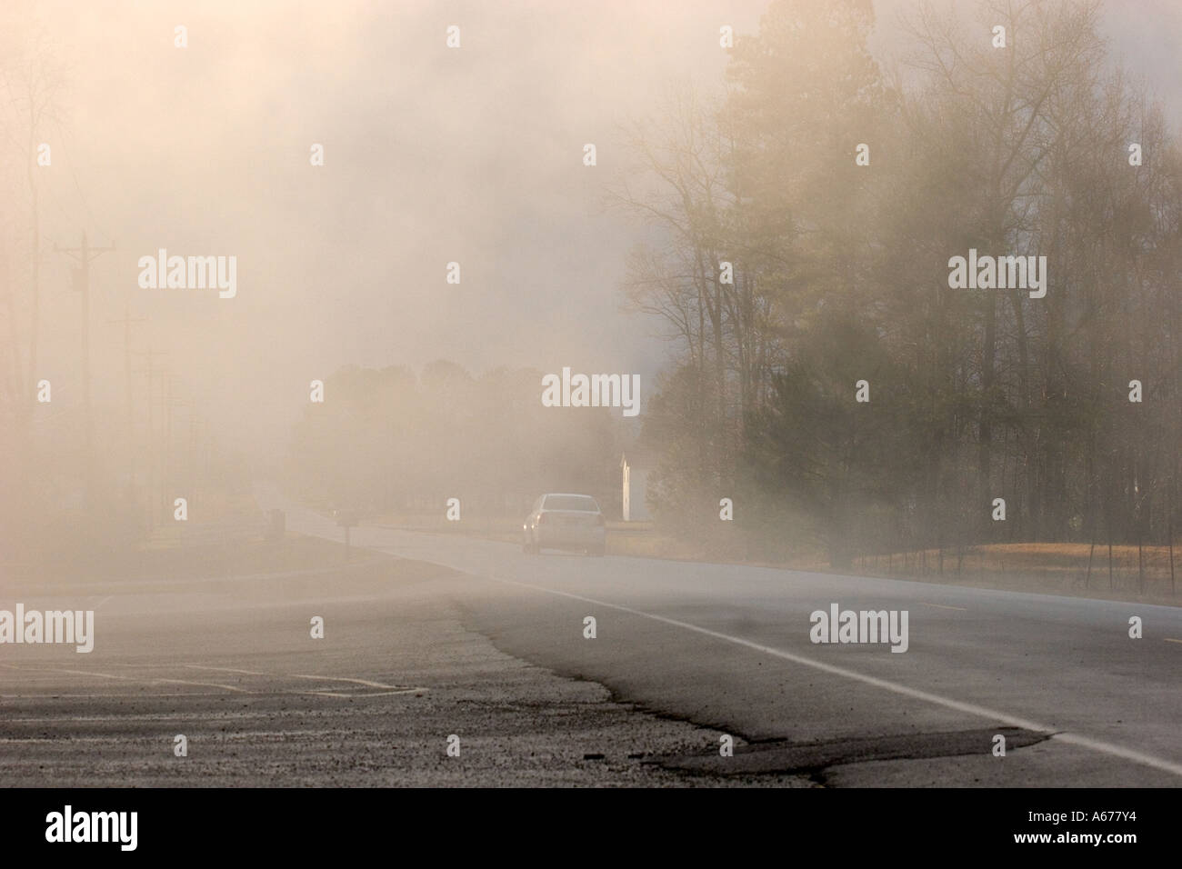 Car driving through smoke during dusk Stock Photo - Alamy