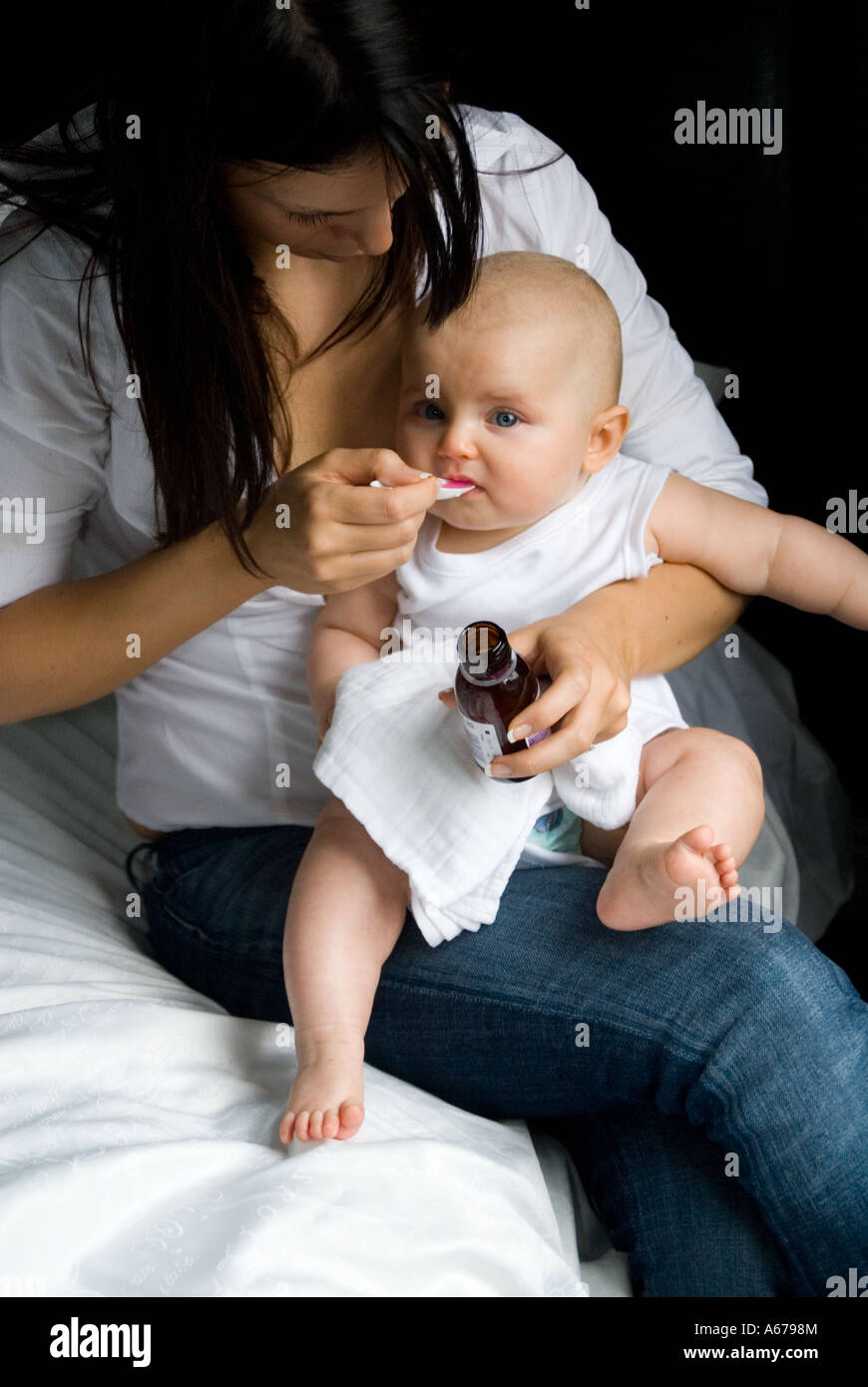Mother gives baby medicine Stock Photo - Alamy