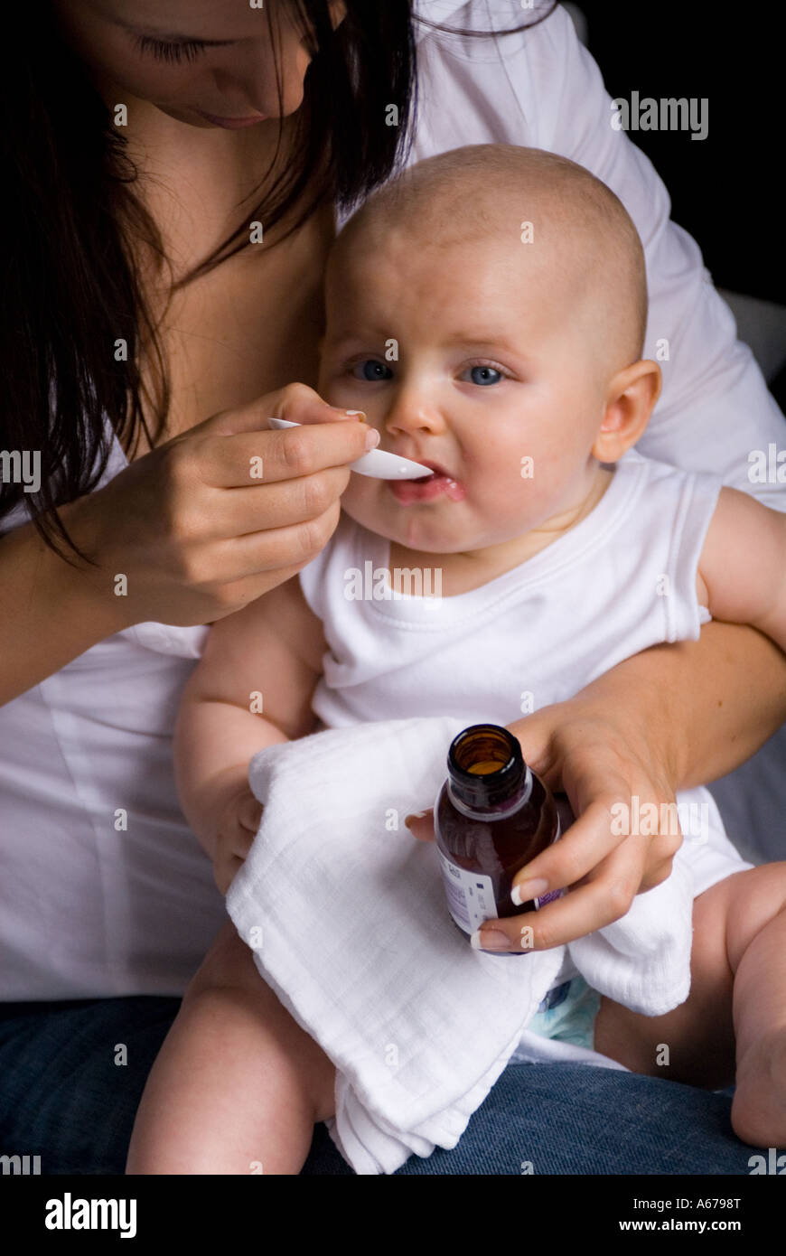 Mother gives baby medicine Stock Photo - Alamy