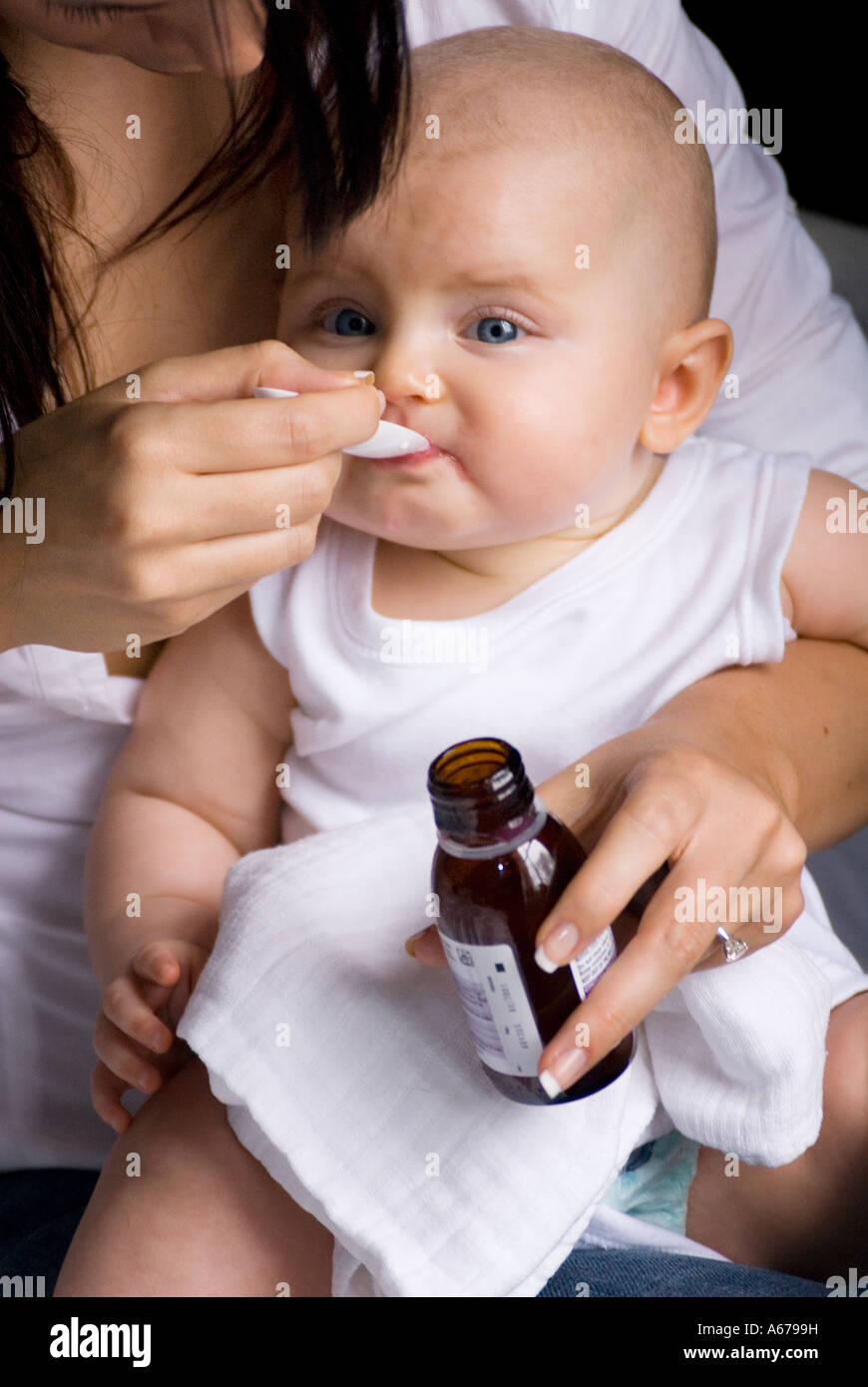 Mother gives baby medicine Stock Photo - Alamy