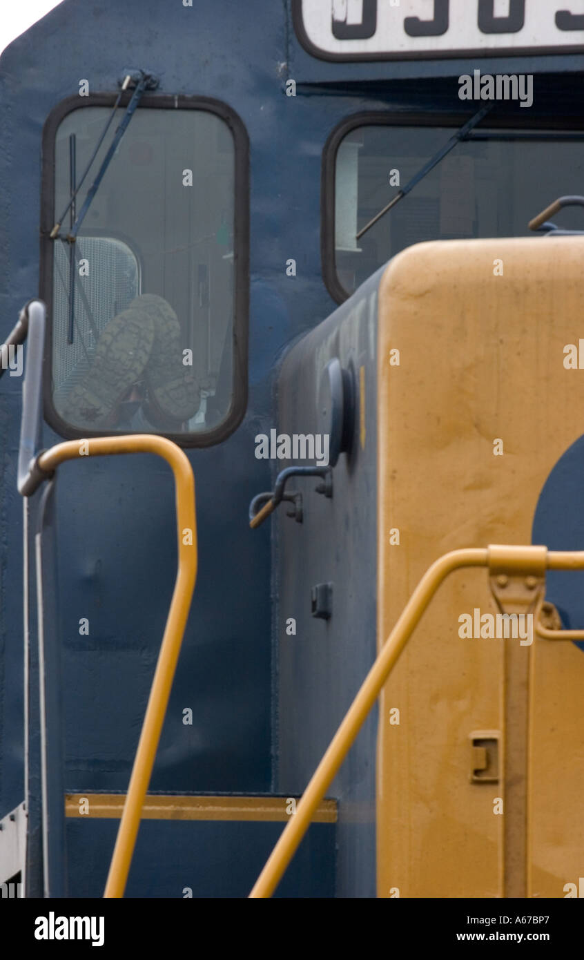 Crop of diesel electric locomotive cab with engineer s feet in window ...
