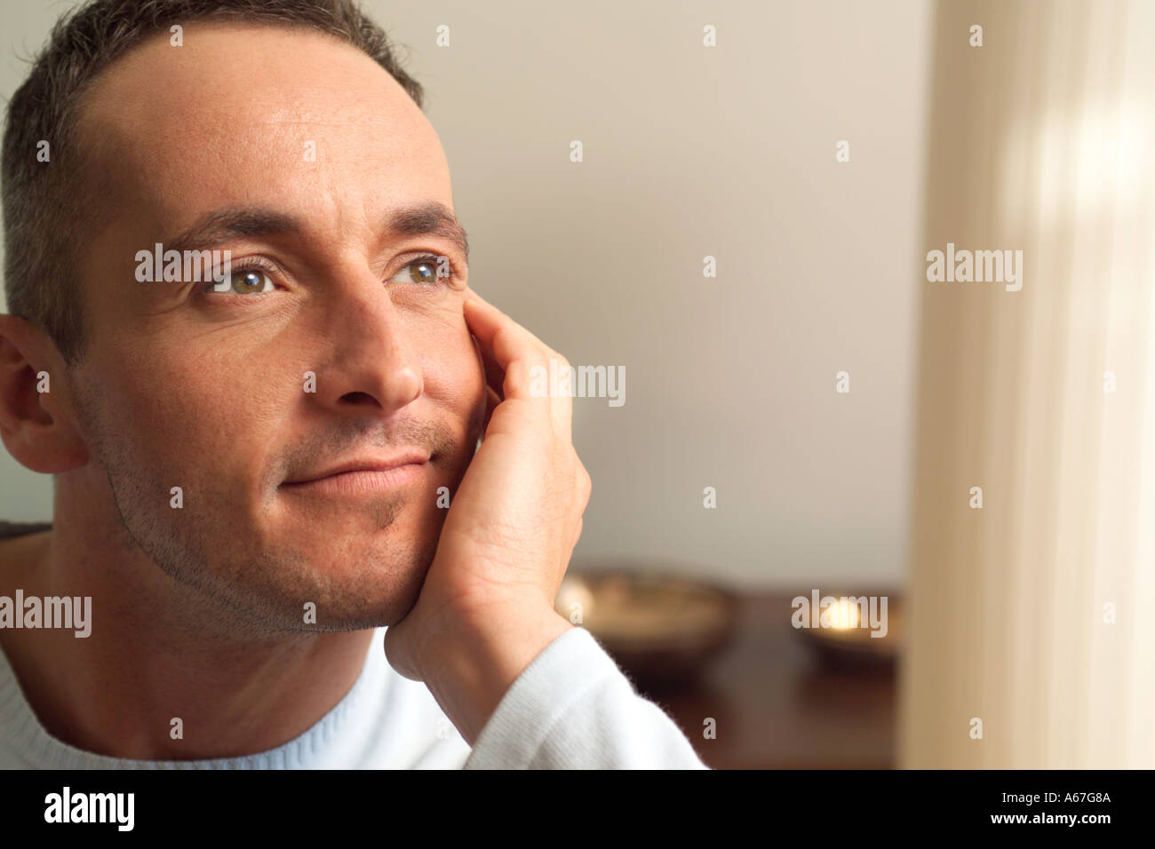 portrait of young man resting his head in one hand Stock Photo - Alamy