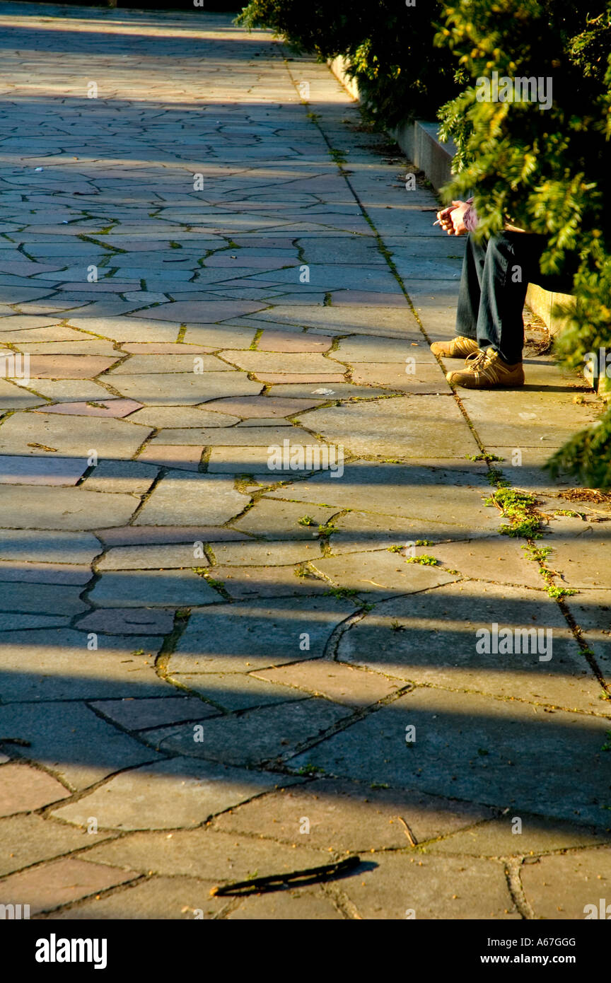 A man smoking a cigarette in a park Stock Photo - Alamy