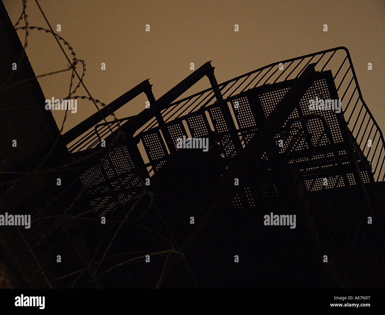 fire escape and barbed wire at night Stock Photo - Alamy