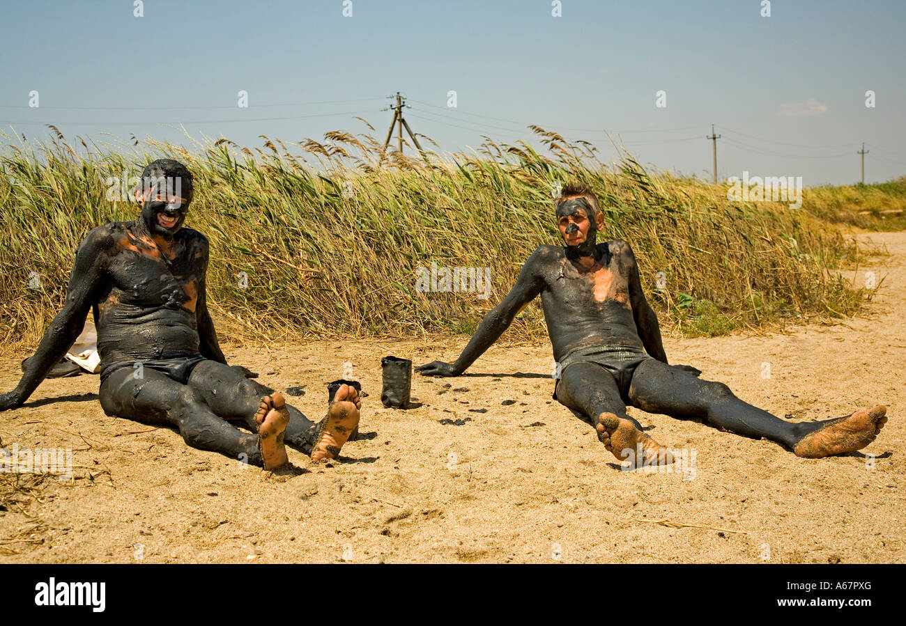 Men cover their body with therapeutic mud from the Lagoon of Saki ...