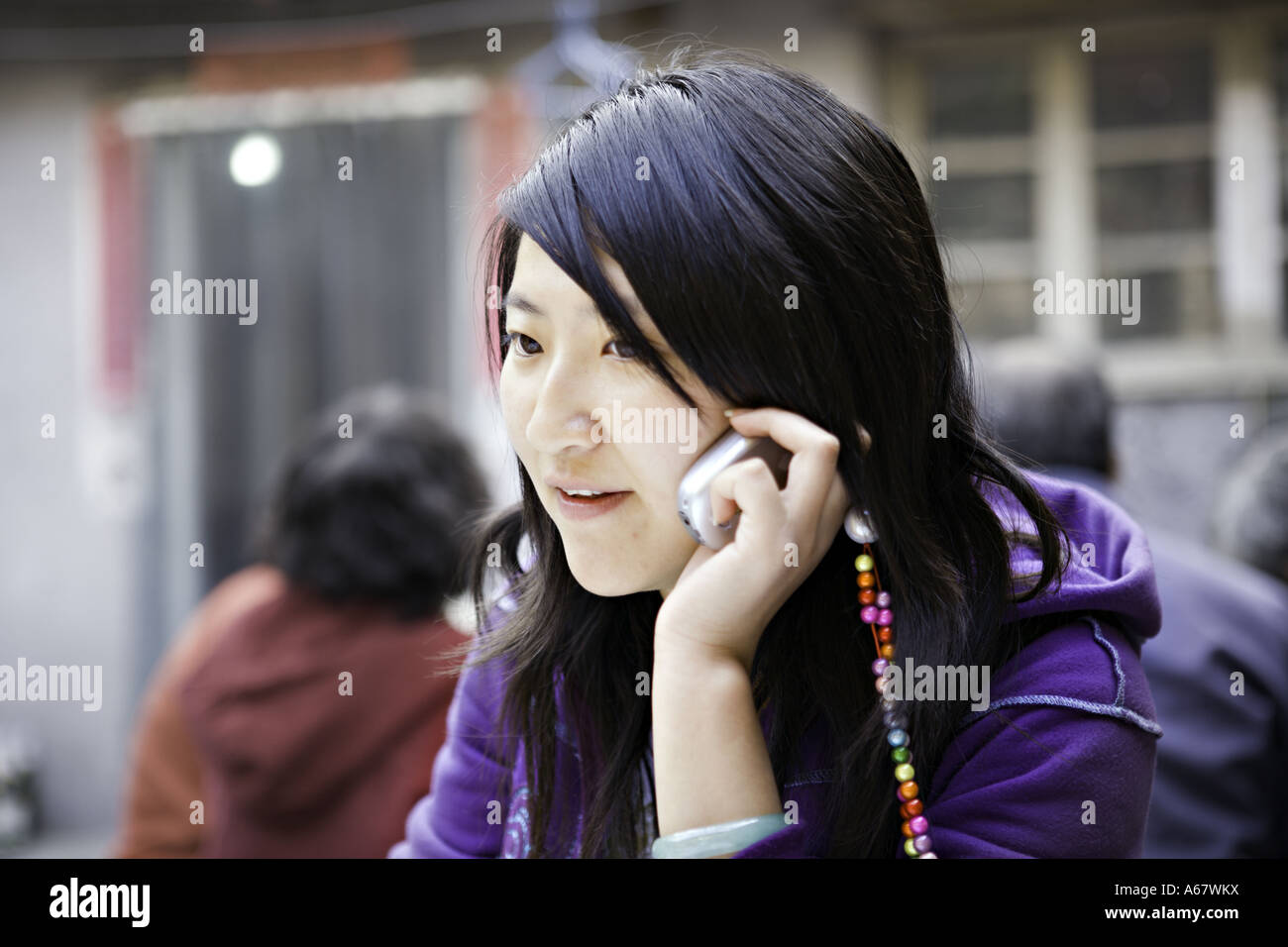 CHINA Chuandixia Modern young Chinese woman talking on her cell phone ...