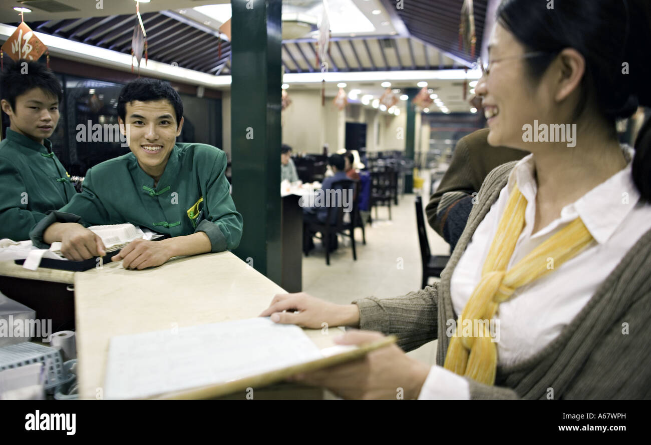 CHINA BEIJING Attractive young Chinese tour guide reviews menu choices ...