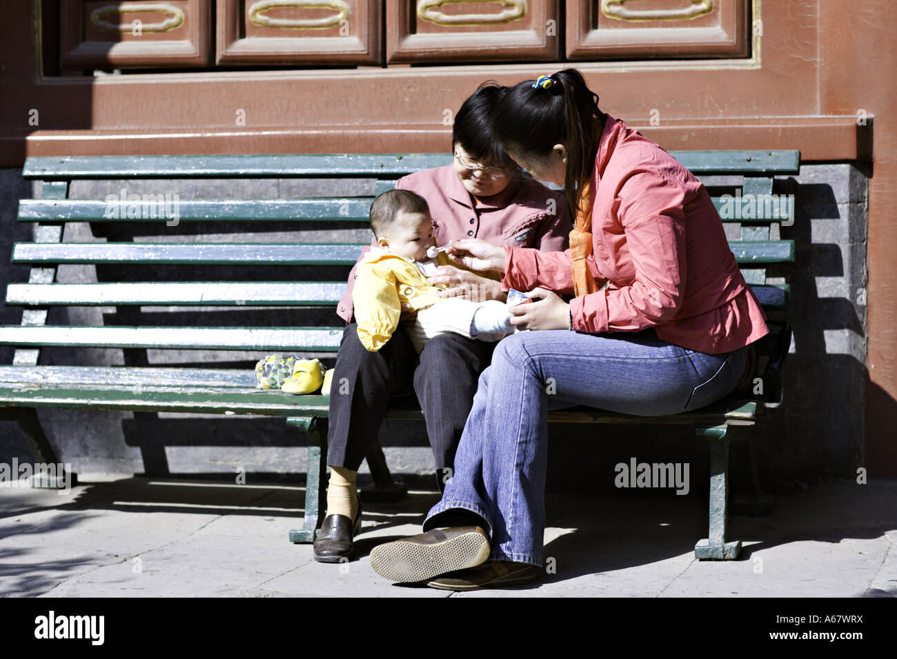 CHINA BEIJING Young Chinese mother feeds her baby a snack of yogurt ...
