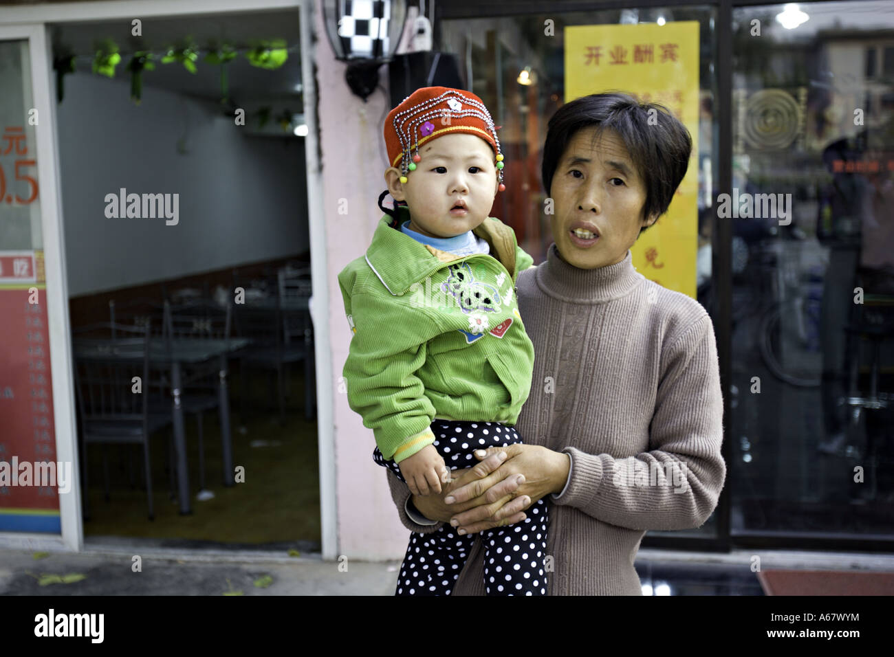 CHINA BEIJING Chinese mother holding her traditionally dressed infant ...