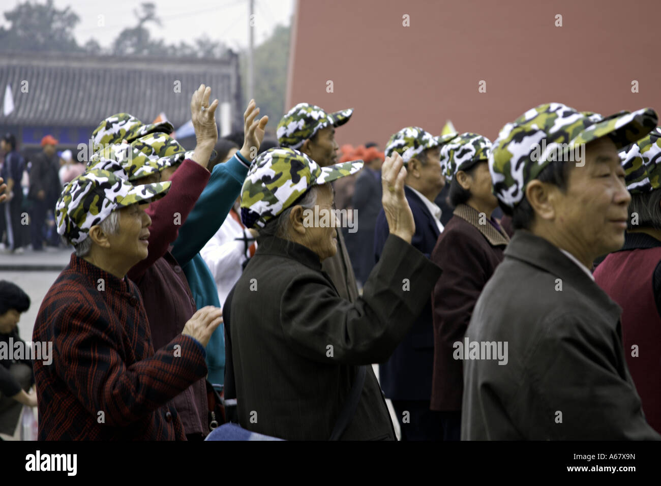CHINA BEIJING Chinese tour group wearing camouflage baseball caps wave ...