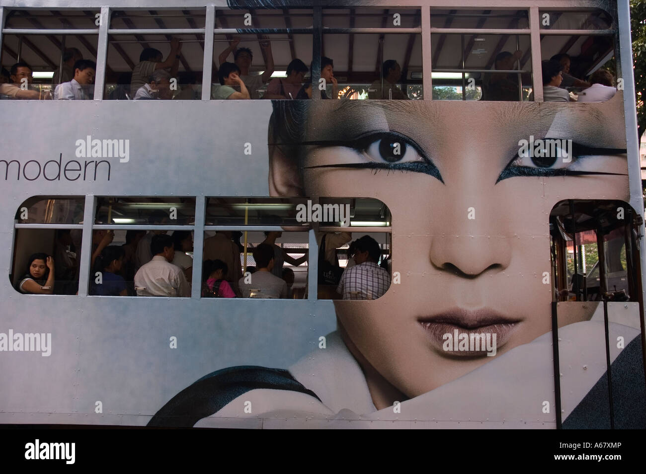 Stock photograph of a public tram covered in bold advertising in Hong ...