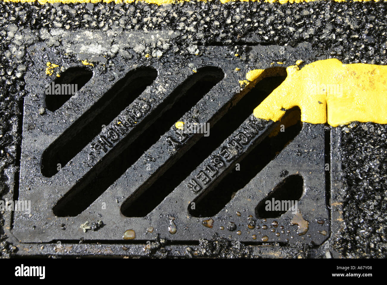 tarmac gutter grate with yellow line Stock Photo - Alamy