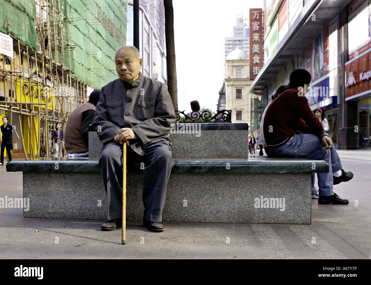 CHINA SHANGHAI Elderly Chinese man with a cane sitting and enjoying the ...