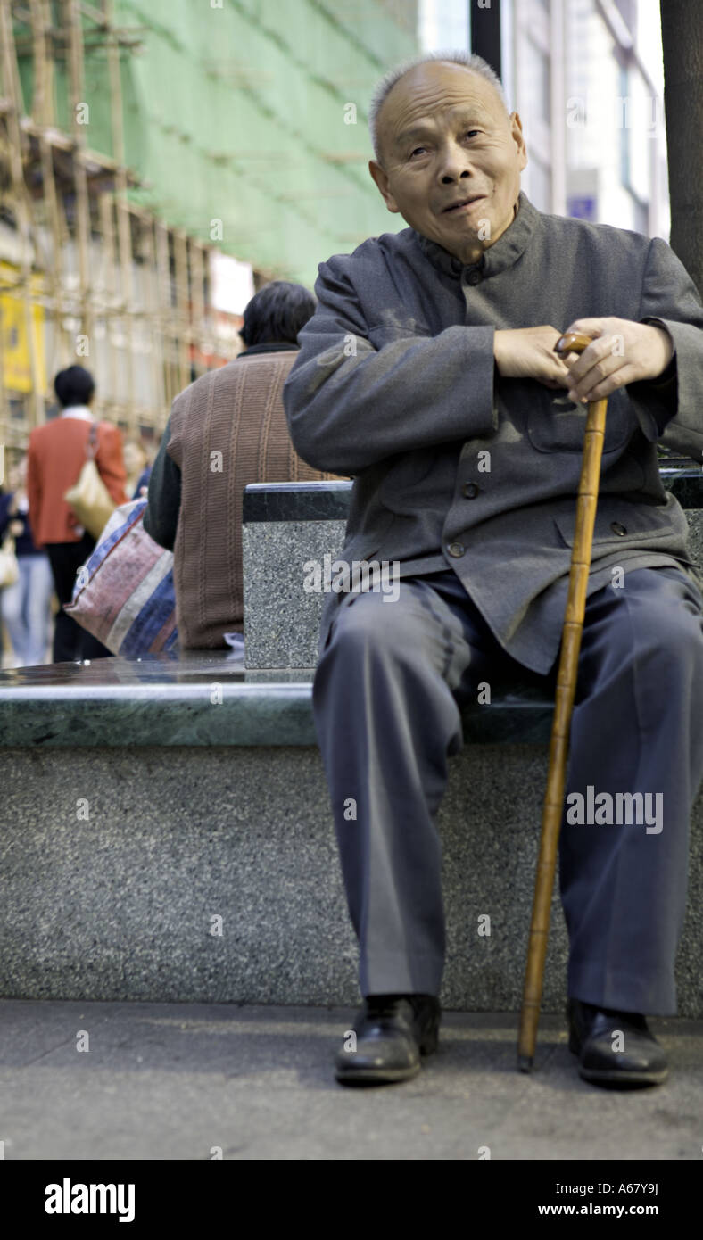 CHINA SHANGHAI Elderly Chinese man with a cane sitting and enjoying the ...
