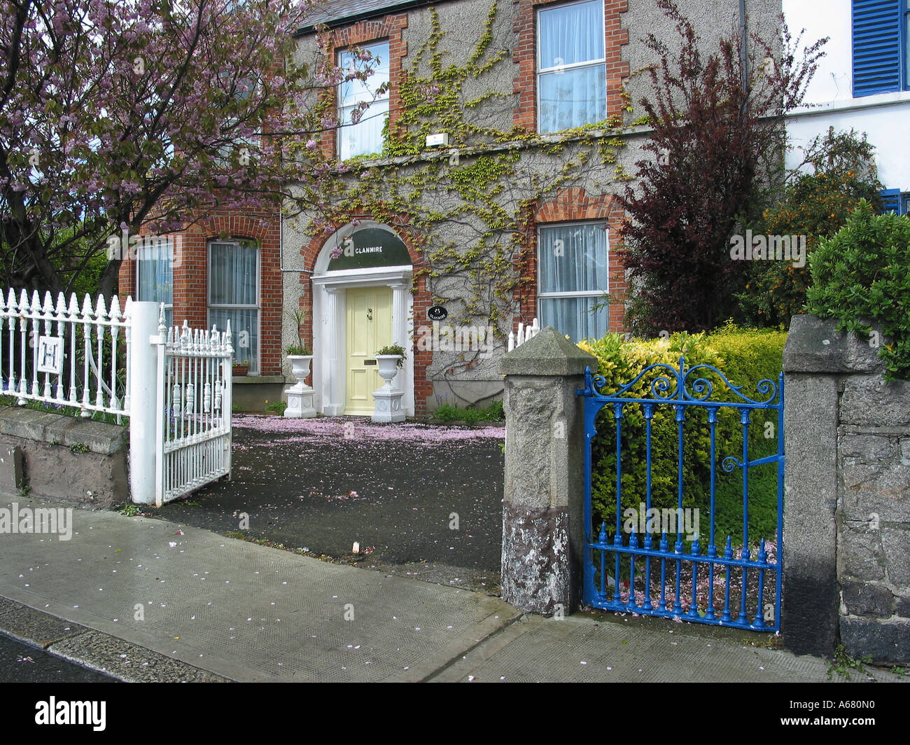 Domestic front garden with entrance gates of residential house in ...