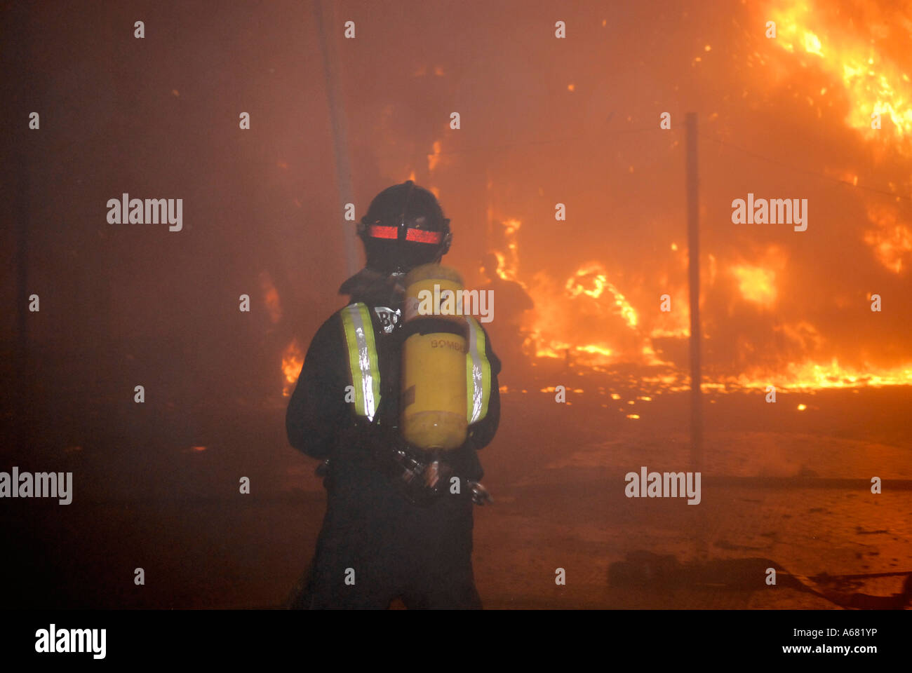 Fireman with oxygen tank on his back putting out massive fire Stock ...