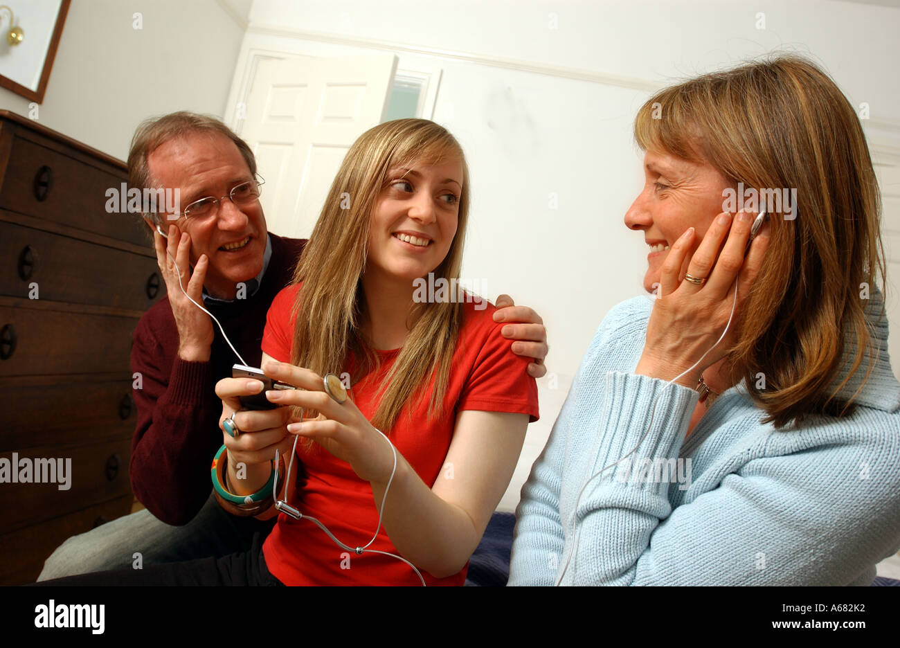 Teenage girl listening to music with her parents Stock Photo - Alamy