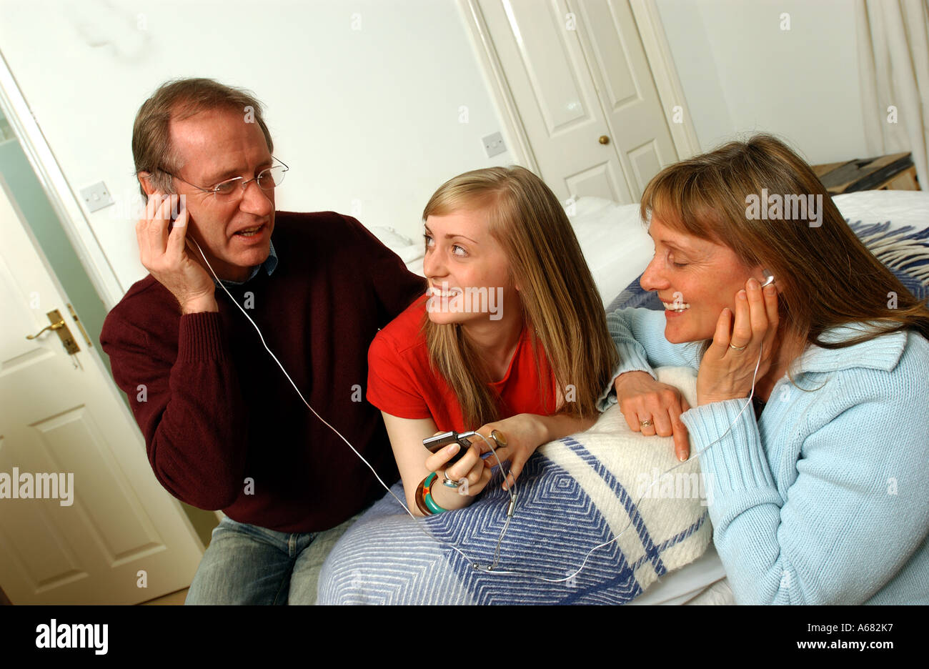 Teenage girl listening to music with her parents Stock Photo - Alamy