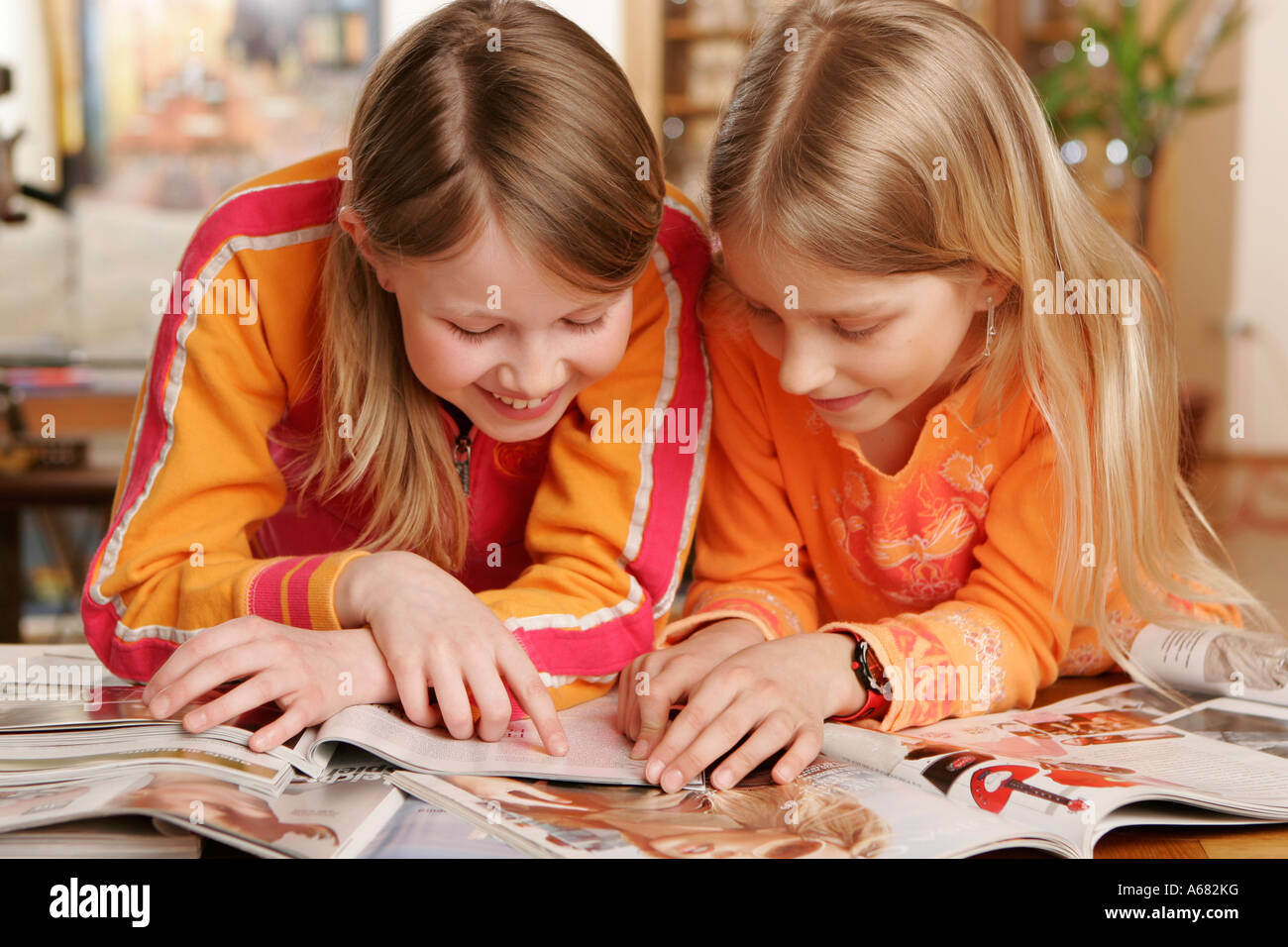Two young girls read magazines Stock Photo - Alamy