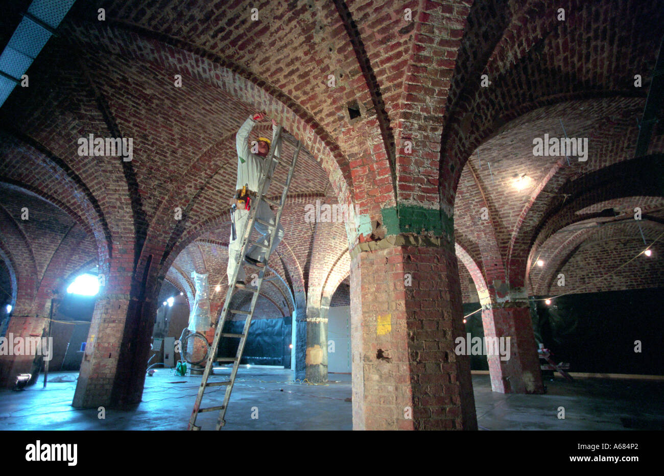An electrician installying lights in Victorian Gothic style brick ...