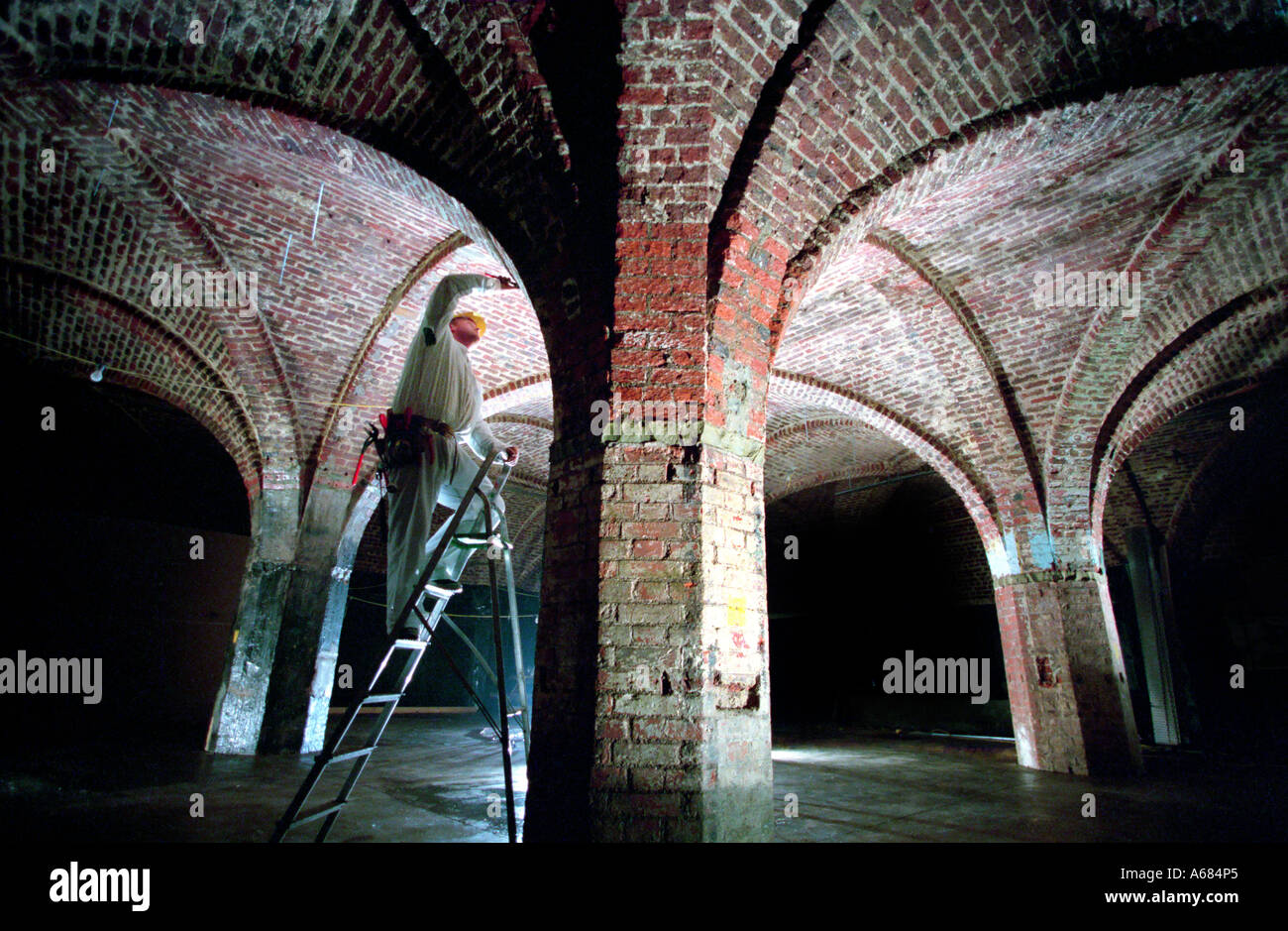 An electrician installying lights in Victorian Gothic style brick ...