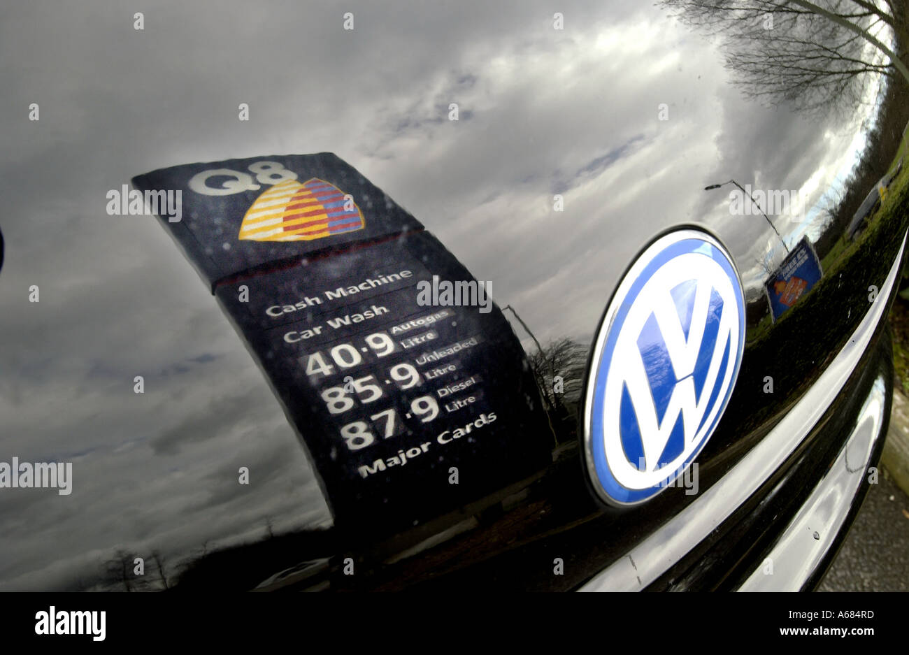 A Q8 petrol station sign reflected in the bonnet of a VW Beetle in a ...